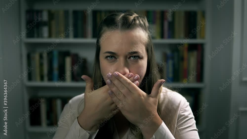 Vidéo Stock The lady is sitting in the studio in front of bookshelf and ...