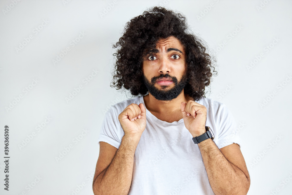 scared curly arabian young guy stand in fear by something, look at ...