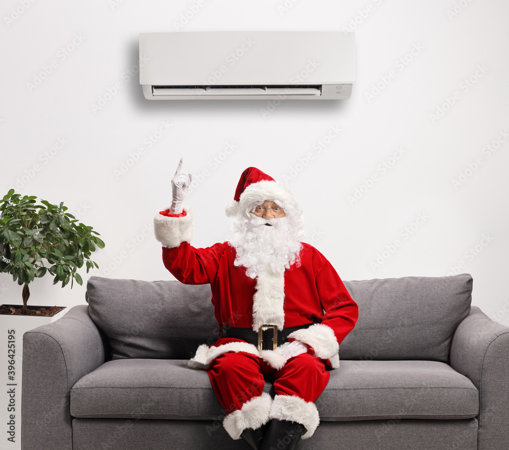 Santa claus sitting on a sofa and pointing to an air conditioning unit ...