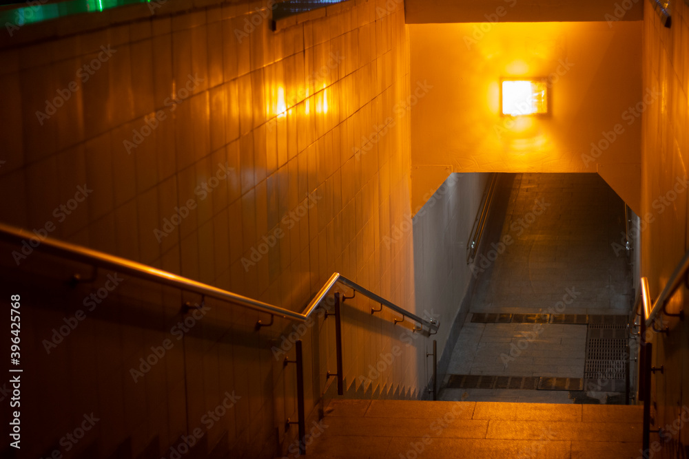 Underground passage under the road at night. Staircase down in the city ...
