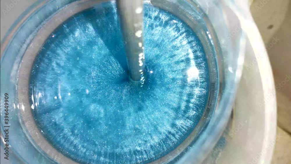 Mixing epoxy resin with blue pigment. Epoxy bubbles are evaporates at ...