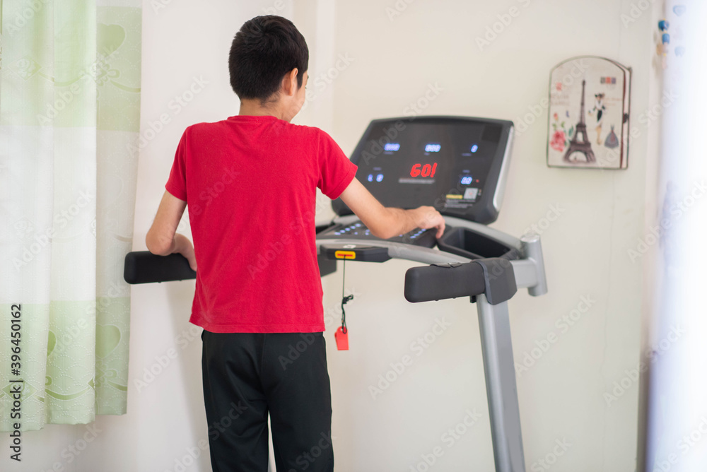 Teen boy running on treadmill for exercise Stock Photo | Adobe Stock