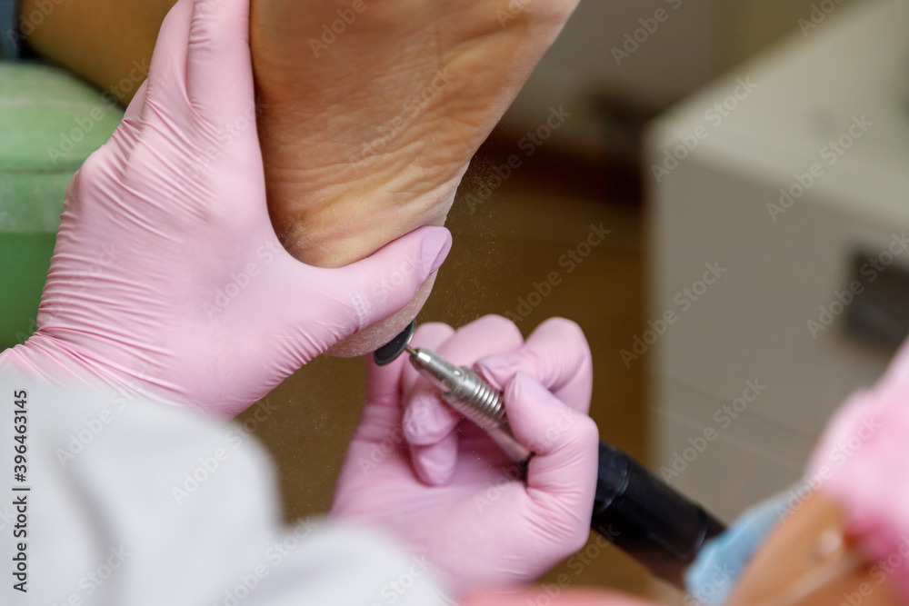 Women's feet and pedicure master. Professional hardware pedicure in a ...