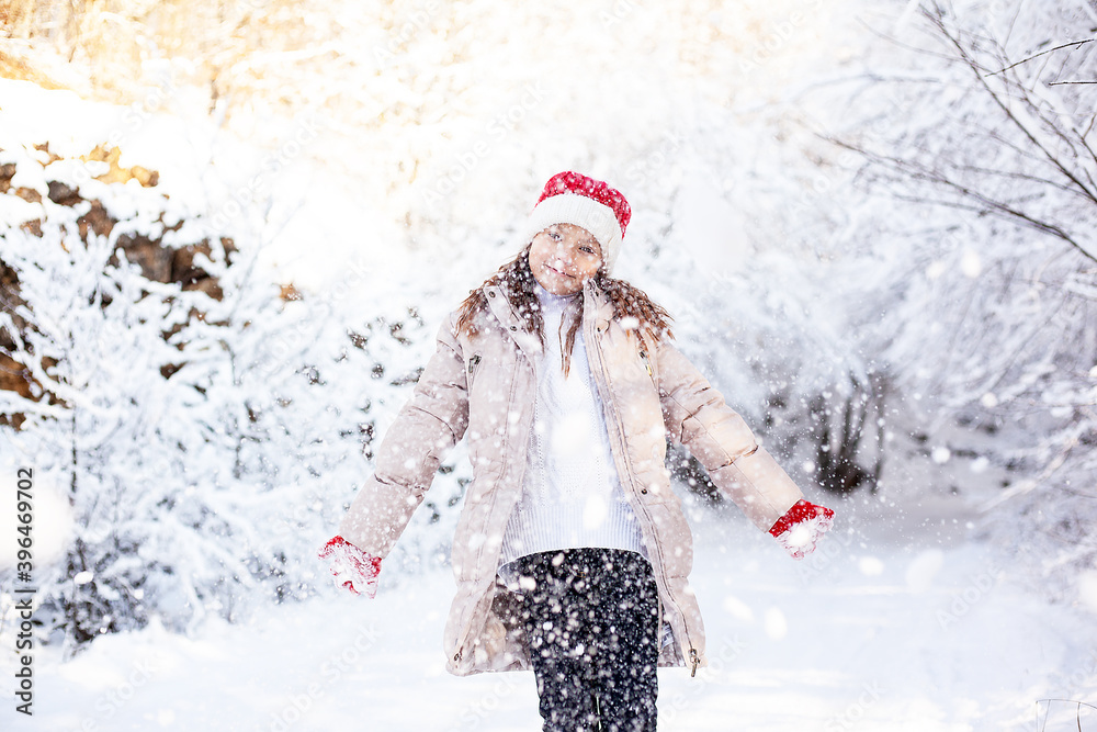 Happy girl playing with snow in frosty winter . The snoflakes flying ...