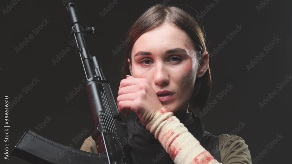 Seductive military woman with short haircut poses in dark background ...