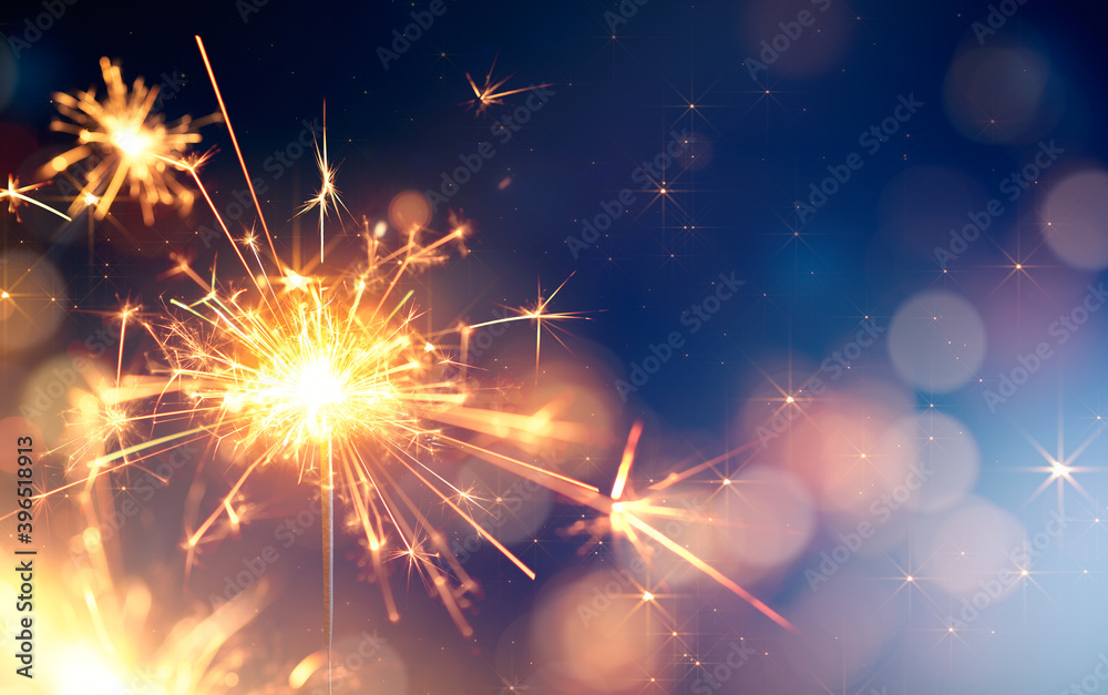 Glittering sparkler against bokeh light background with copy space ...