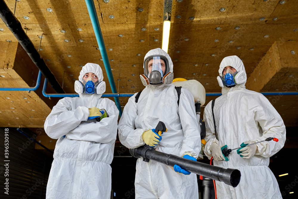 medical workers disinfecting public place, staff is wearing PPE ...