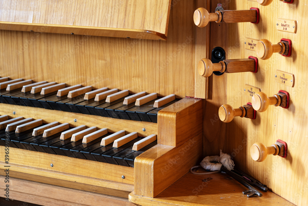Part of a pipe organ console with two keyboards or manuals and wooden ...