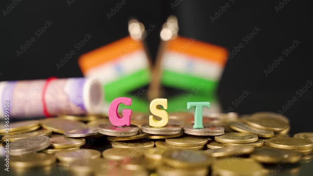 Zoom in view of GST letters placed on coins with indian flag and ...