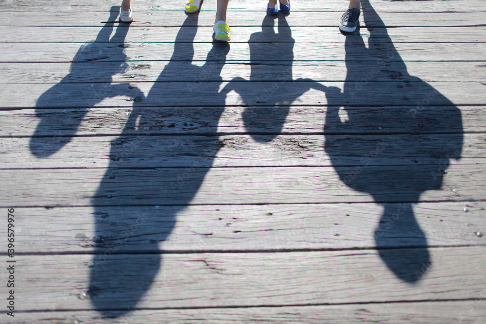 Family of four shadows walking on the terrace. Shadow on the terrace of ...