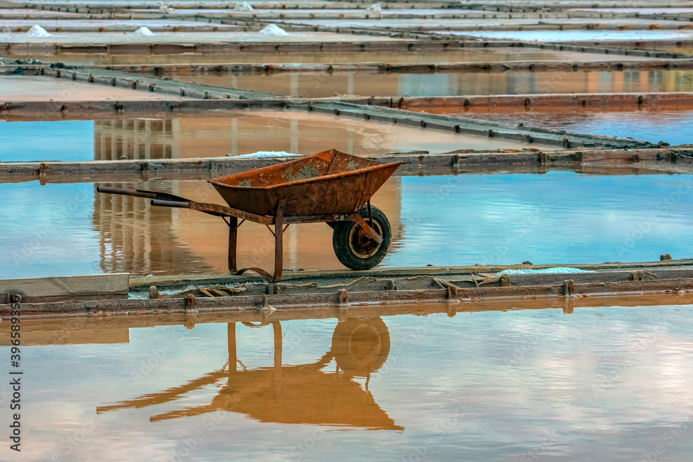 Hand cart for salt covered with rust reflected in Pomorie saltpan ...