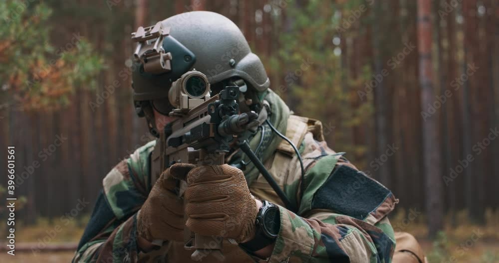 A bearded soldier in a tactical military uniform, with a helmet on his ...