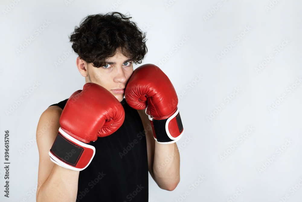 Teen boxer boy in red boxing gloves and focused face, the guy is ready ...