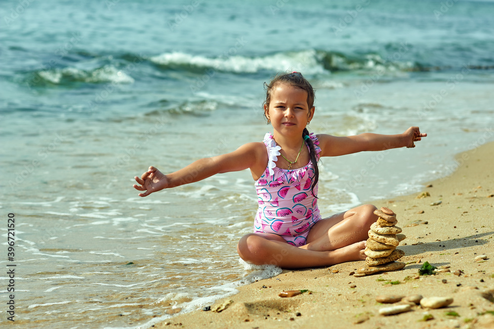 Little girl on vacation at a seaside resort . A child in a bathing suit ...