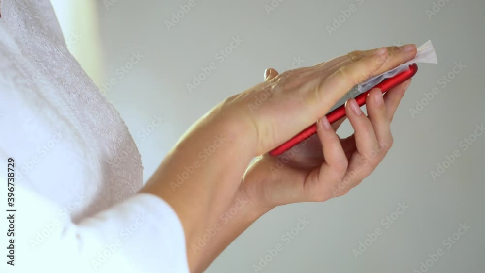 Close-up of woman hand using wet wipe and sanitizer to clean cell phone ...