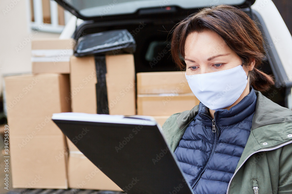 Delivery service with face mask checks deliveries in front of the hold ...
