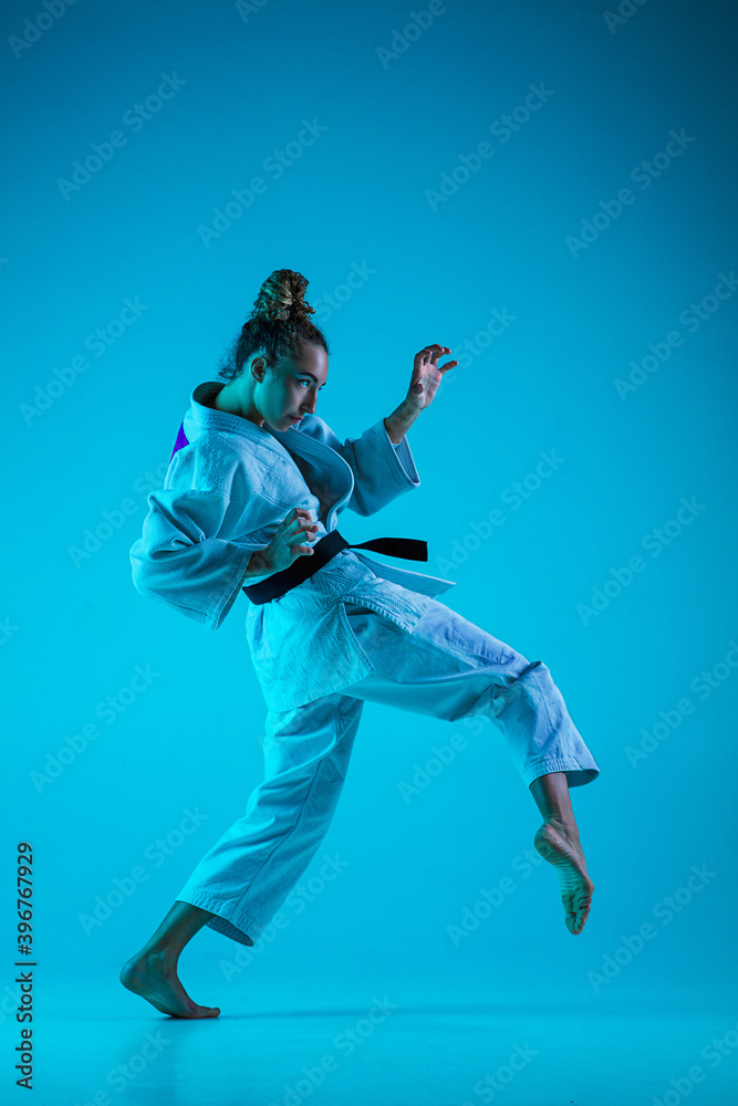 Active training. Professional female judoist in white judo kimono ...