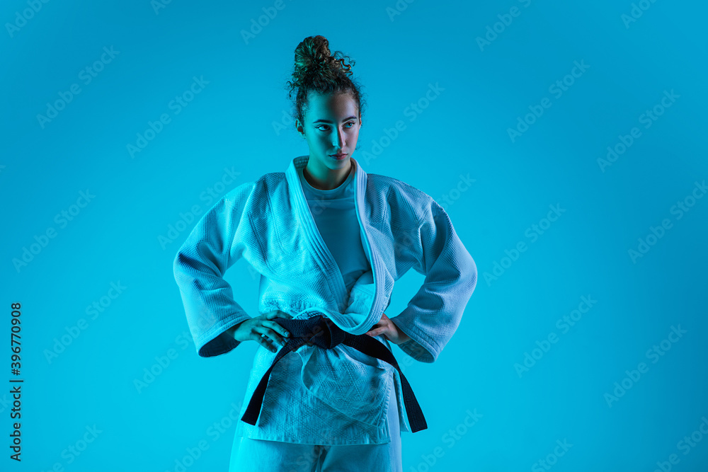 Posing. Professional female judoist in white judo kimono practicing and ...