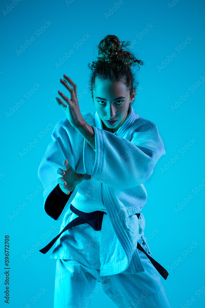 Attack. Professional female judoist in white judo kimono practicing and ...