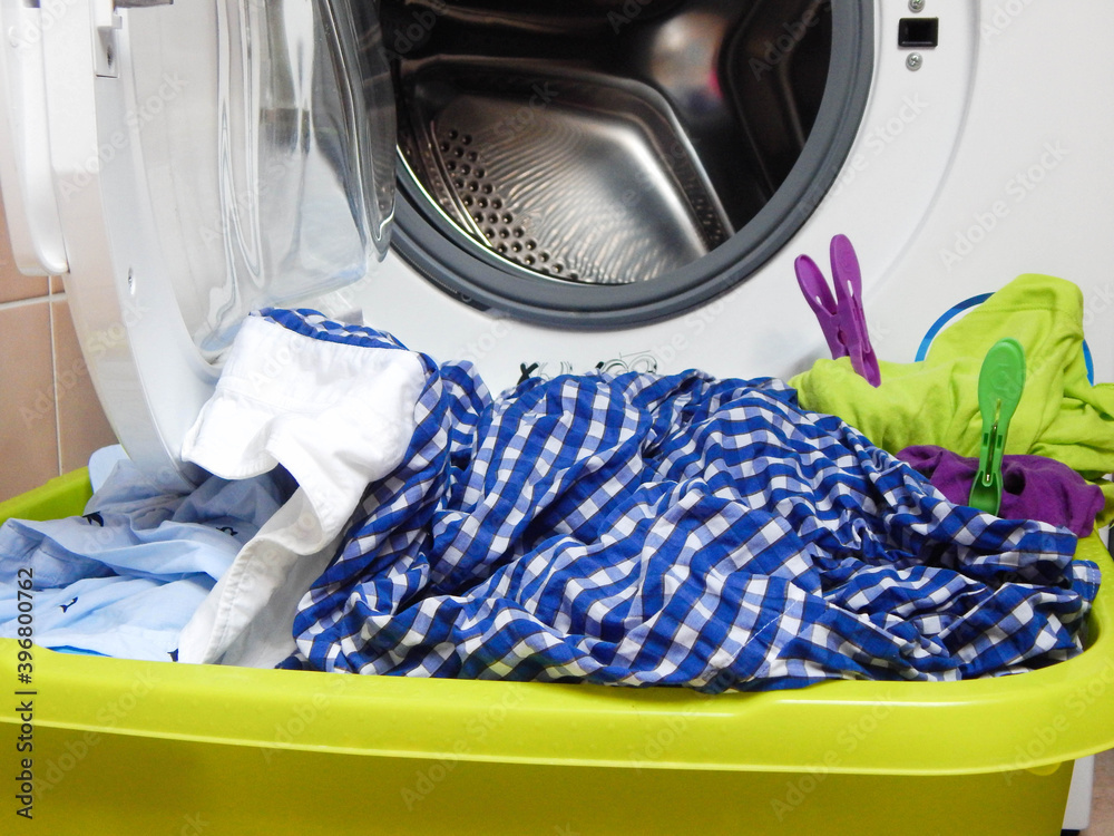 Foamy washing machine with different clothes. Stock Photo | Adobe Stock