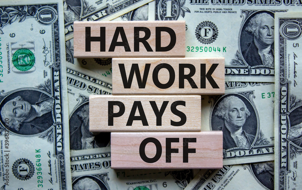 Hard work pays off symbol. Stack of wooden blocks with words 'hard work ...