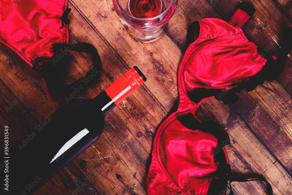 ladies red bra and knickers with a bottle of red wine and wine glass on ...