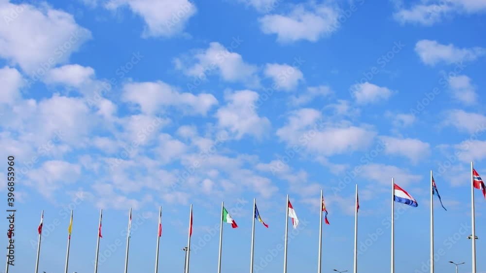 Flags of different countries sway in the wind against the background of ...