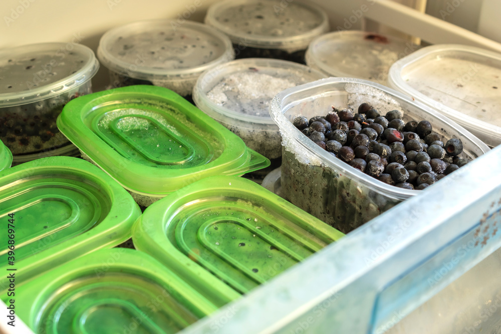 Frozen blueberries in the fridge packed in plastic boxes. Stock Photo ...