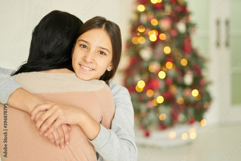 Big hug for Mom. Joyful teenage girl hugging her mother, smiling at ...