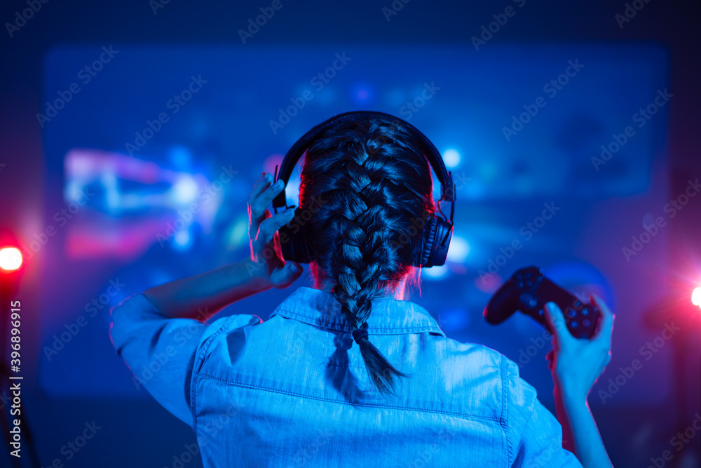 Close-up view from back of emotional gamer woman playing video game at ...
