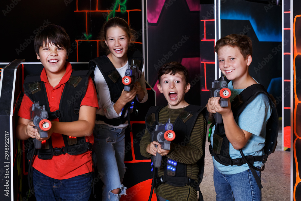 excited happy teen boy and girl aiming laser gun at other players ...