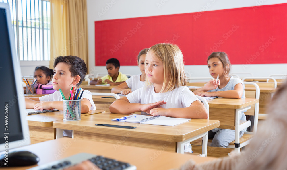 Pupils of primary school listening new theme and attentively watching ...