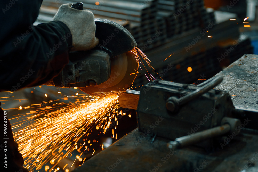 Cutting a metal beam using an electric hand saw. Stock Photo | Adobe Stock
