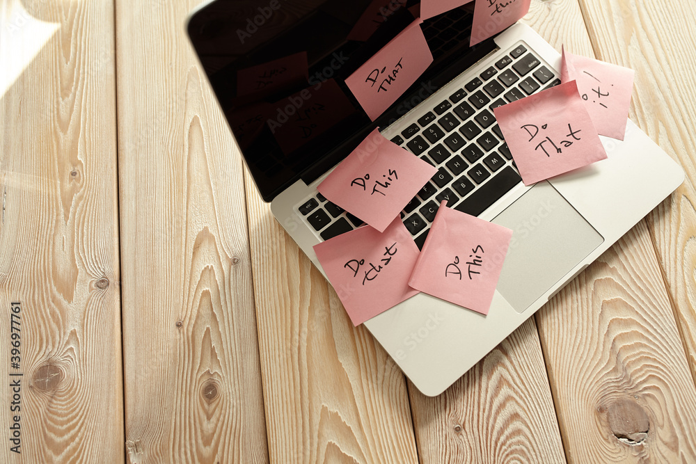 Image of laptop full of sticky notes reminders on screen. Work overload ...