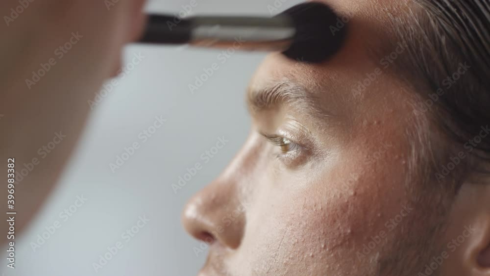 Extreme close up shot of unrecognizable MUA using brush and applying ...