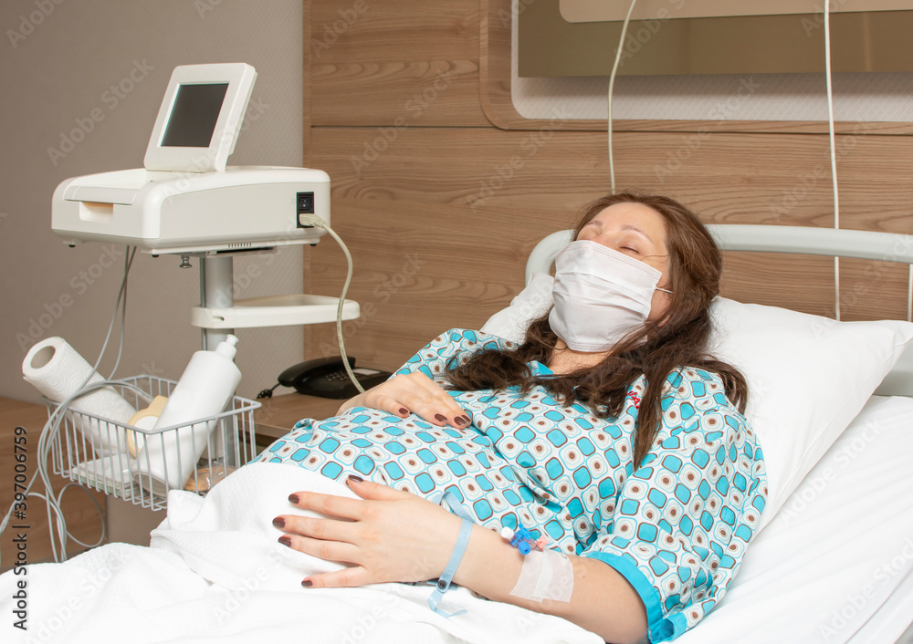 Pregnant woman in newborn hospital lying near fetal heart beat by fetal ...