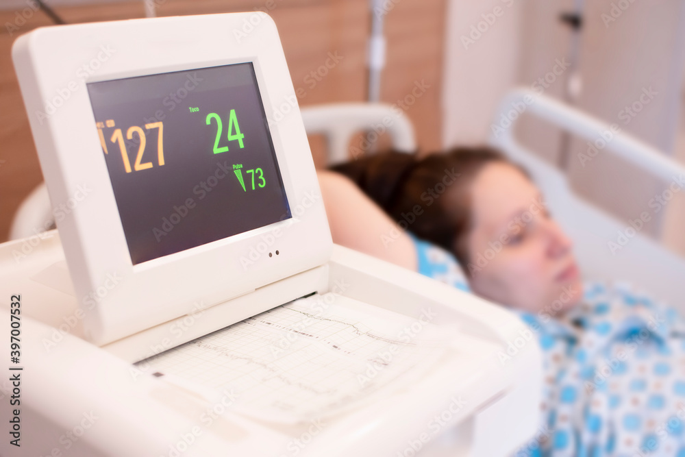 Pregnant woman in newborn hospital lying near fetal heart beat by fetal ...