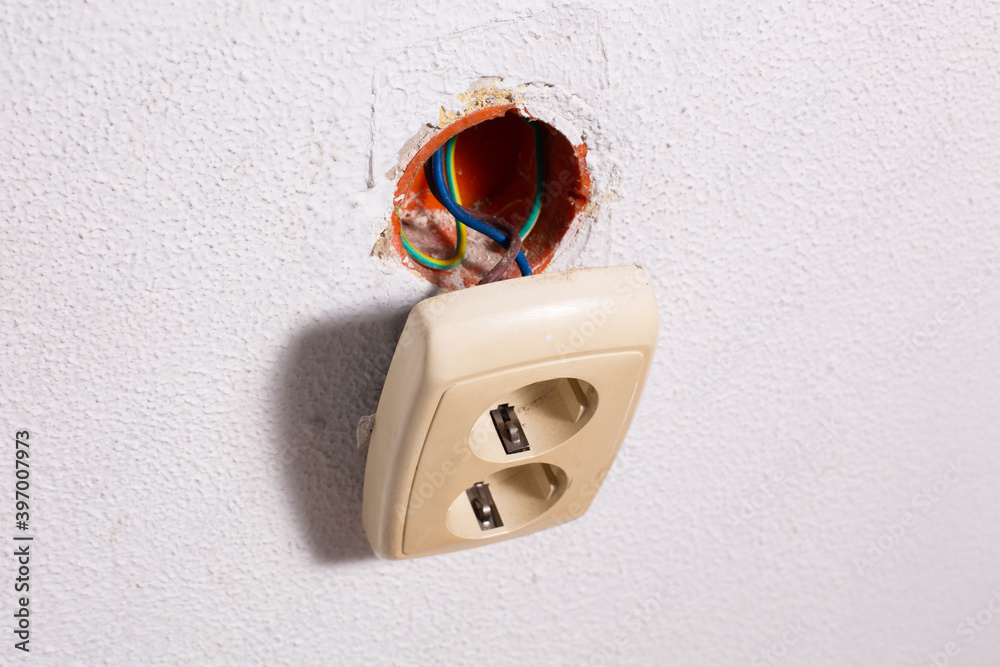 Broken socket hanging from wires in the wall Stock-Foto | Adobe Stock