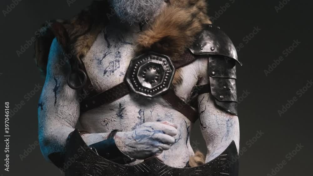 Frozen dead warrior with horns and white skin in dark armour with fur ...