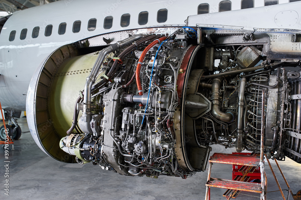 aircraft engine servicing - opened panels of a large engine of parked ...