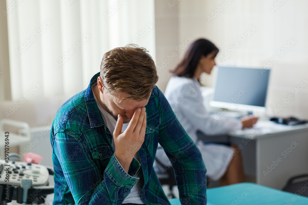 Frustrated middle aged male patient with heavy disease sitting on couch ...