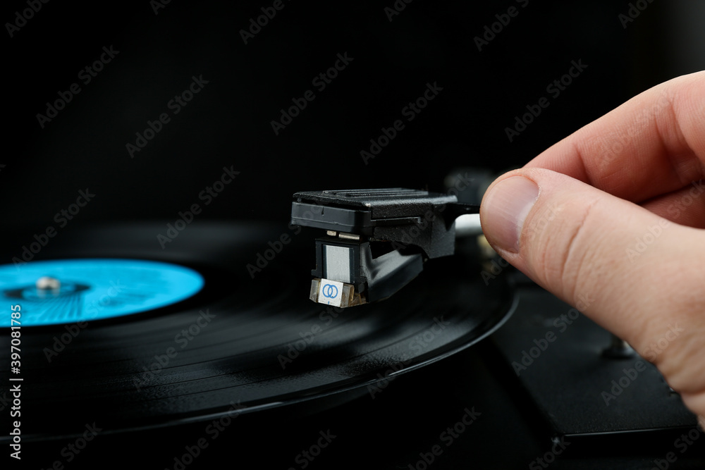 vinyl record on a turntable. turntable head close-up on black ...