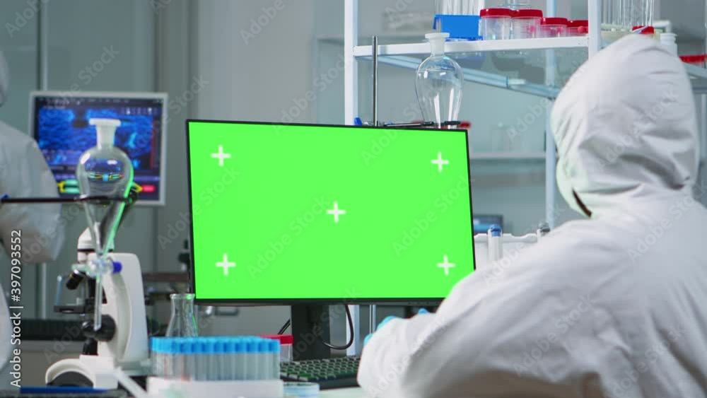 Man researcher in coverall looking at chroma key computer in modern ...