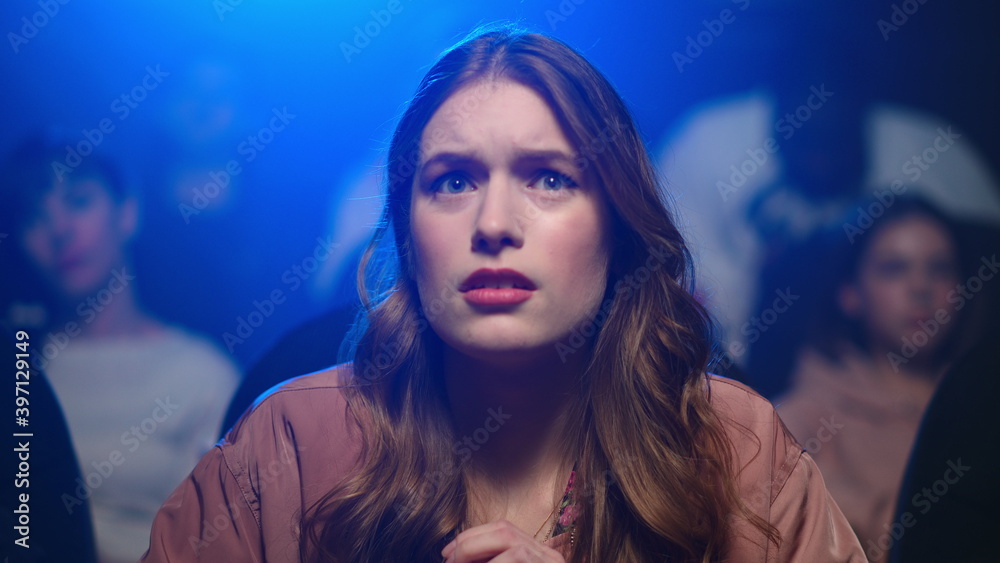 Worried girl watching melodrama in movie theater. Sad woman sitting in ...