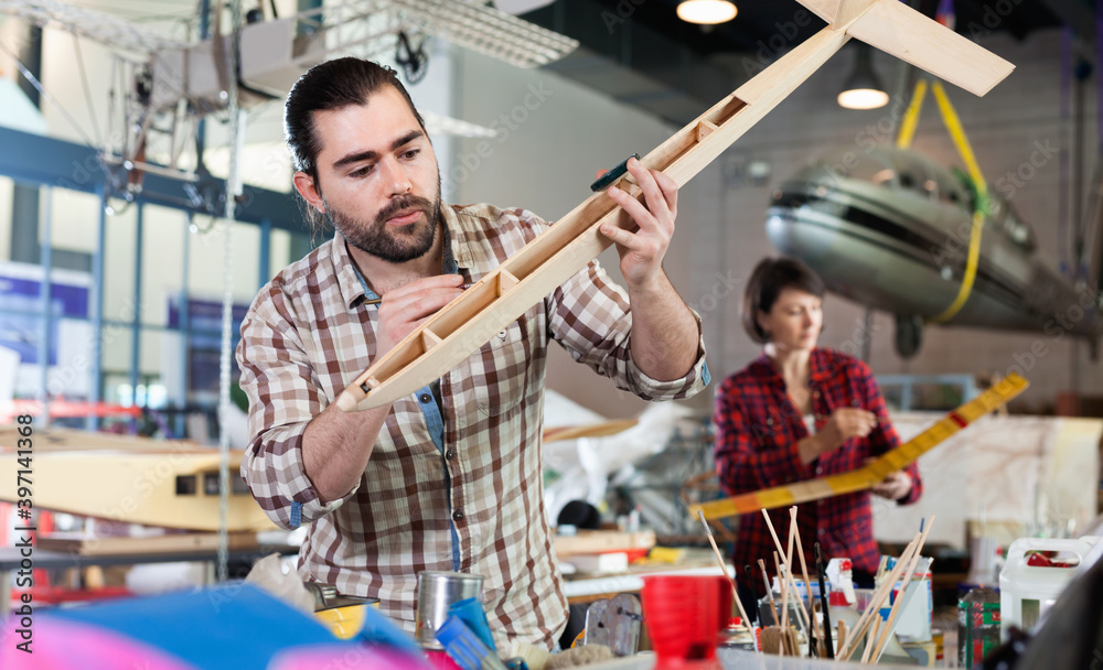 Young positive cheerful smiling handsome bearded man enjoying his hobby ...