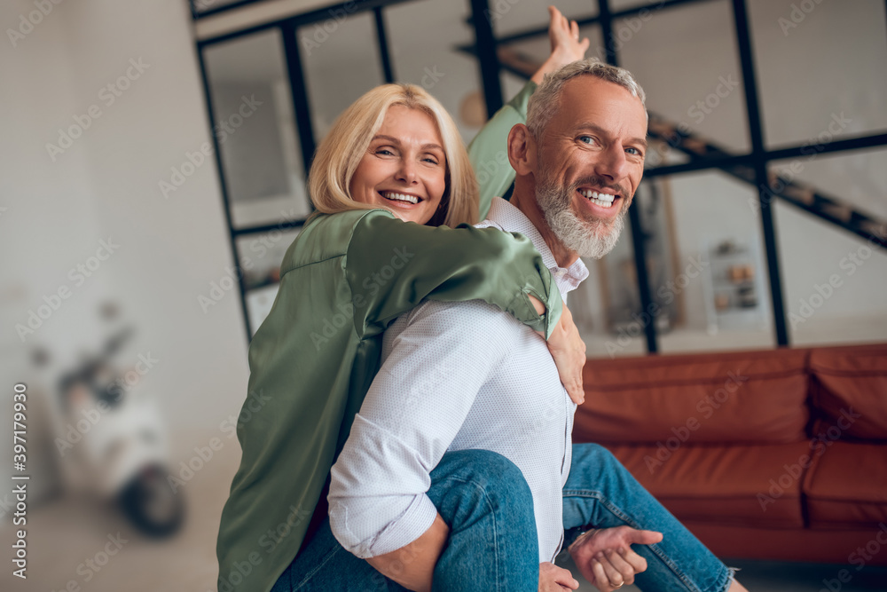 Man holding his wife on his back and both feeling awesome Stock Photo ...