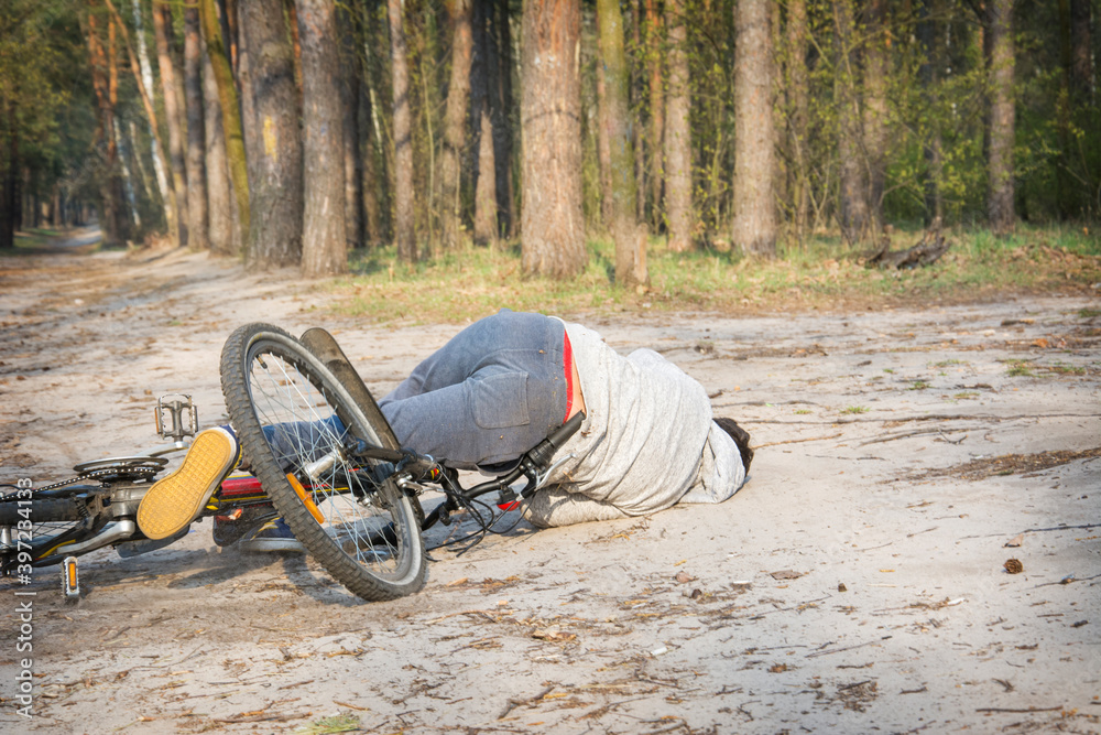 Spring in a pine forest boy fell off his bicycle. Stock Photo | Adobe Stock