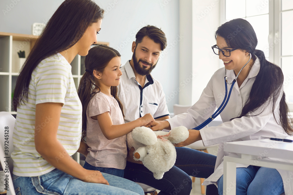 The family doctor listens with a stethoscope to the child with the ...