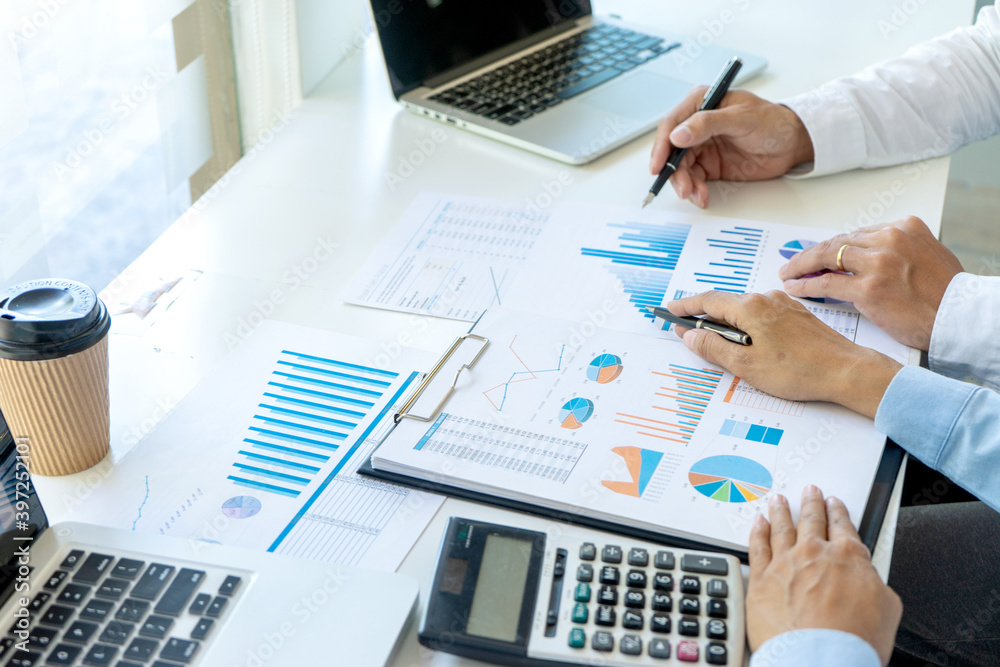 Businessman pointing at graphs paper of business in a graph analysis ...