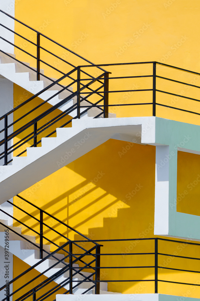Low angle and side view of fire escape outside of yellow building wall ...